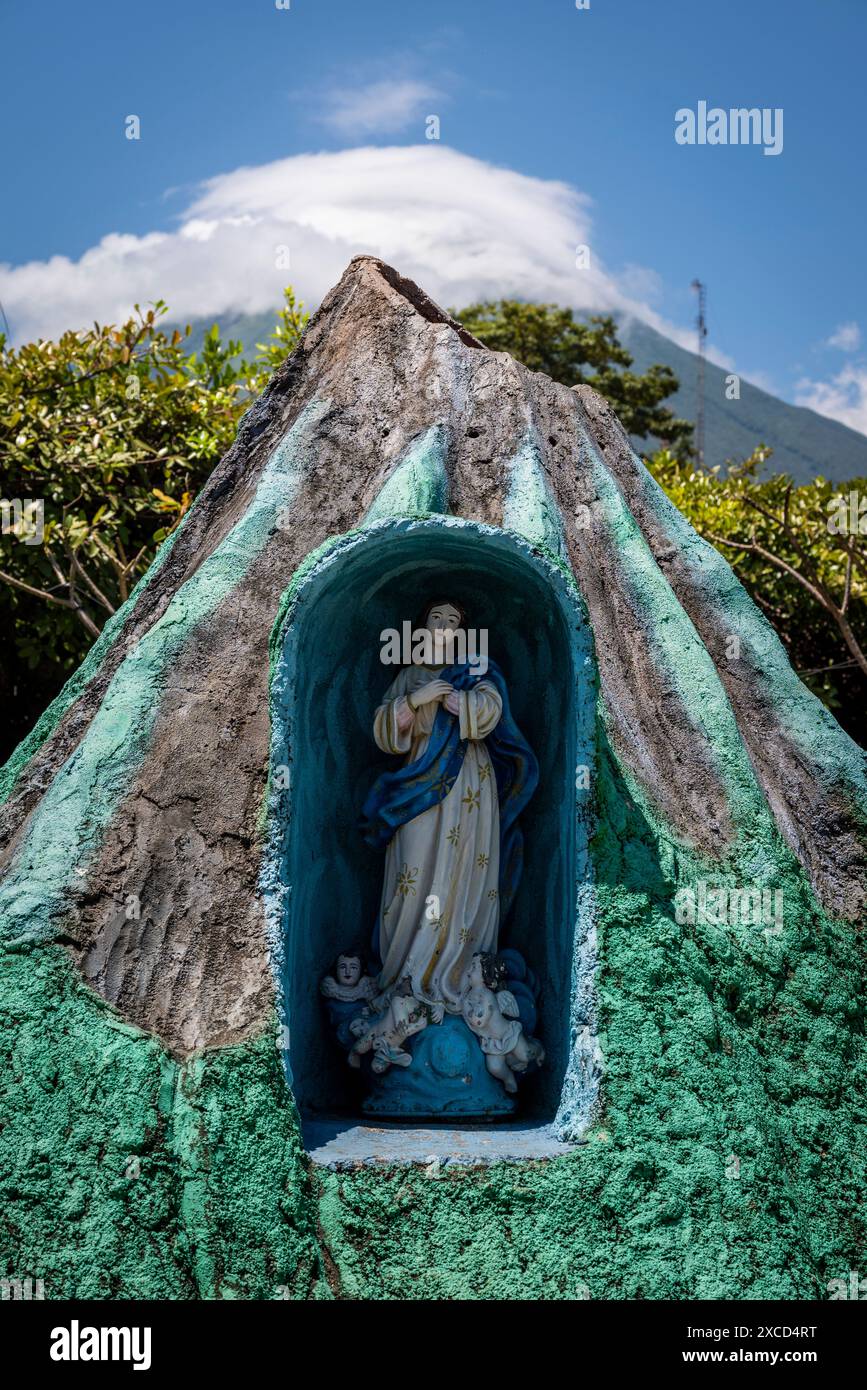 Virgin Mary statue in a volcano shaped structure and real volcano ...