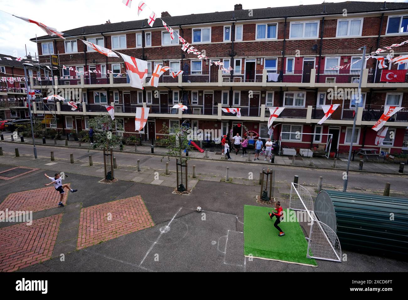 Children playing football surrounded by flags at the Kirby Estate ...