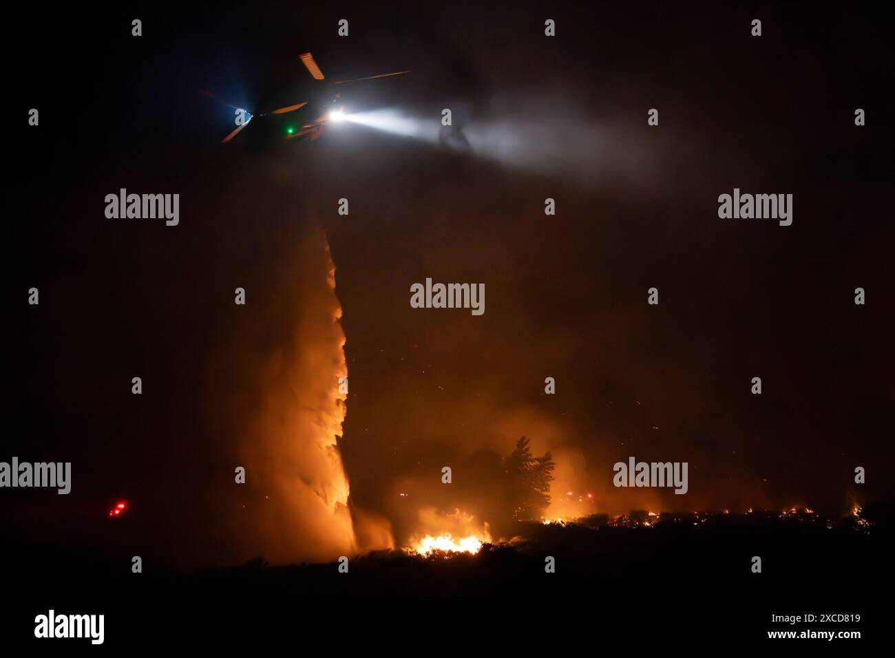 A Cal Fire Helicopter drops water on a fire hot spot. The Post Fire ...