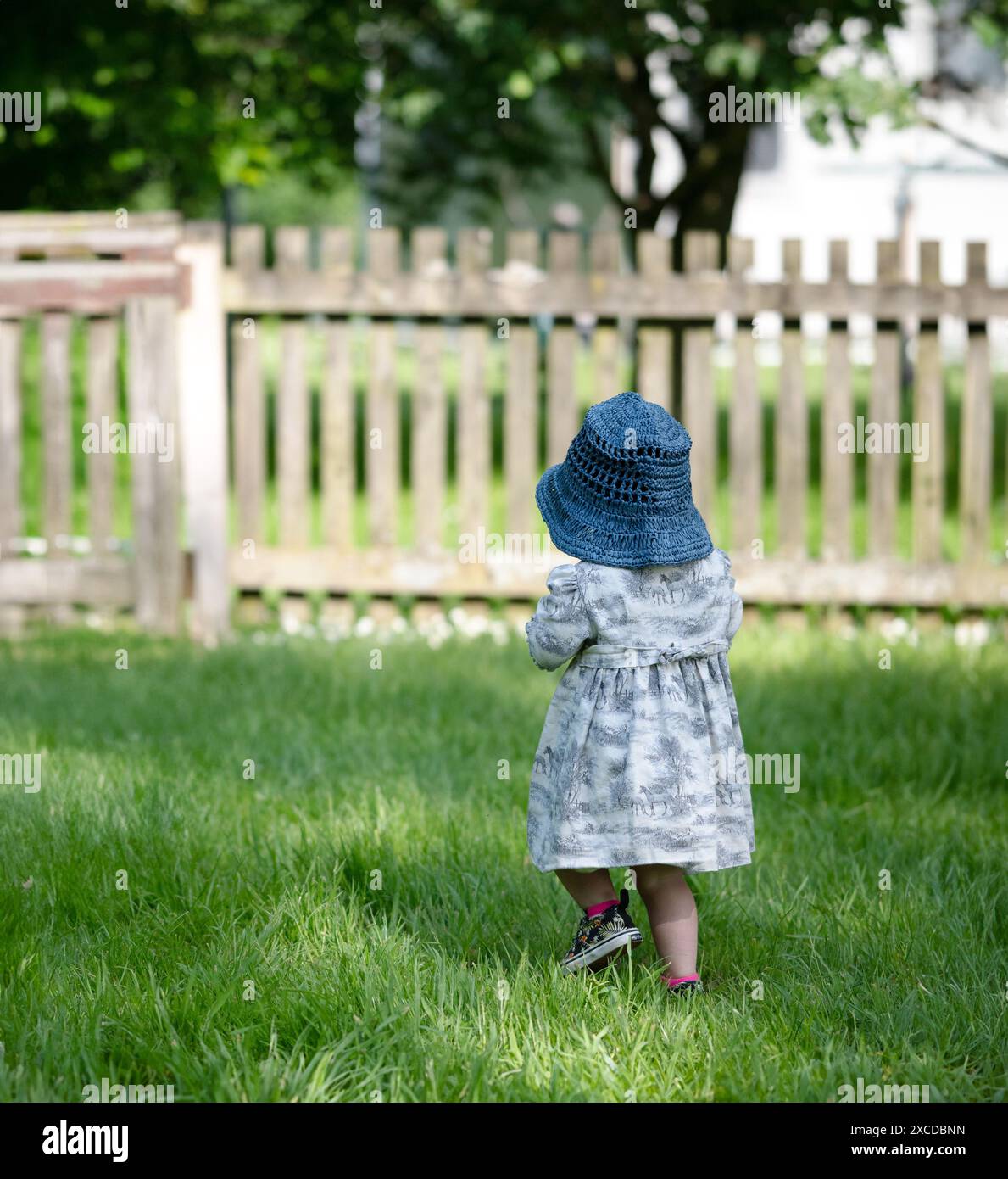 Little girl walking in the park in a big blue sun hat Stock Photo - Alamy