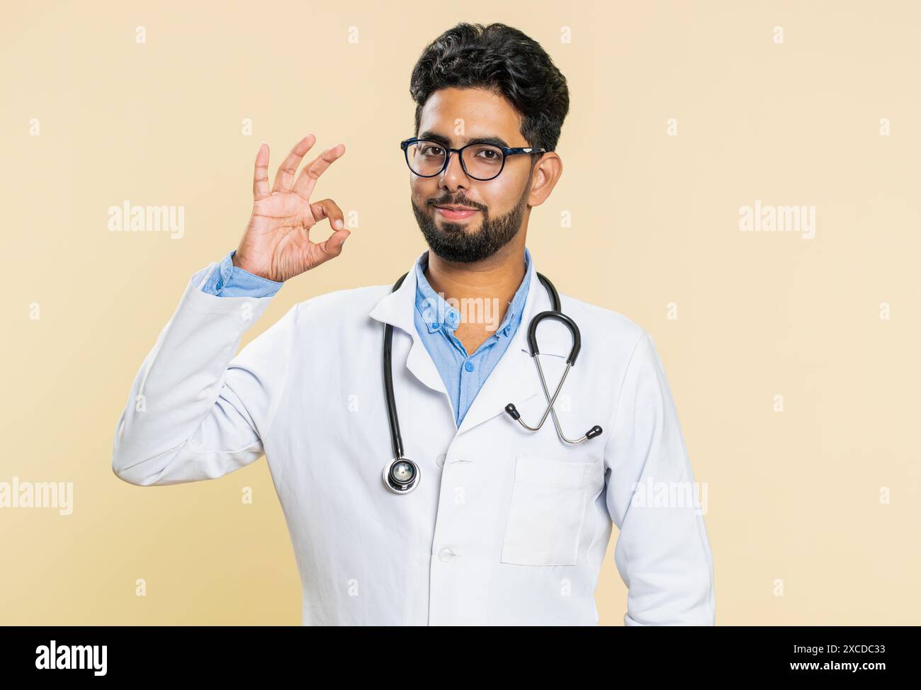Okay. Happy Indian young doctor cardiologist man show ok gesture, like ...