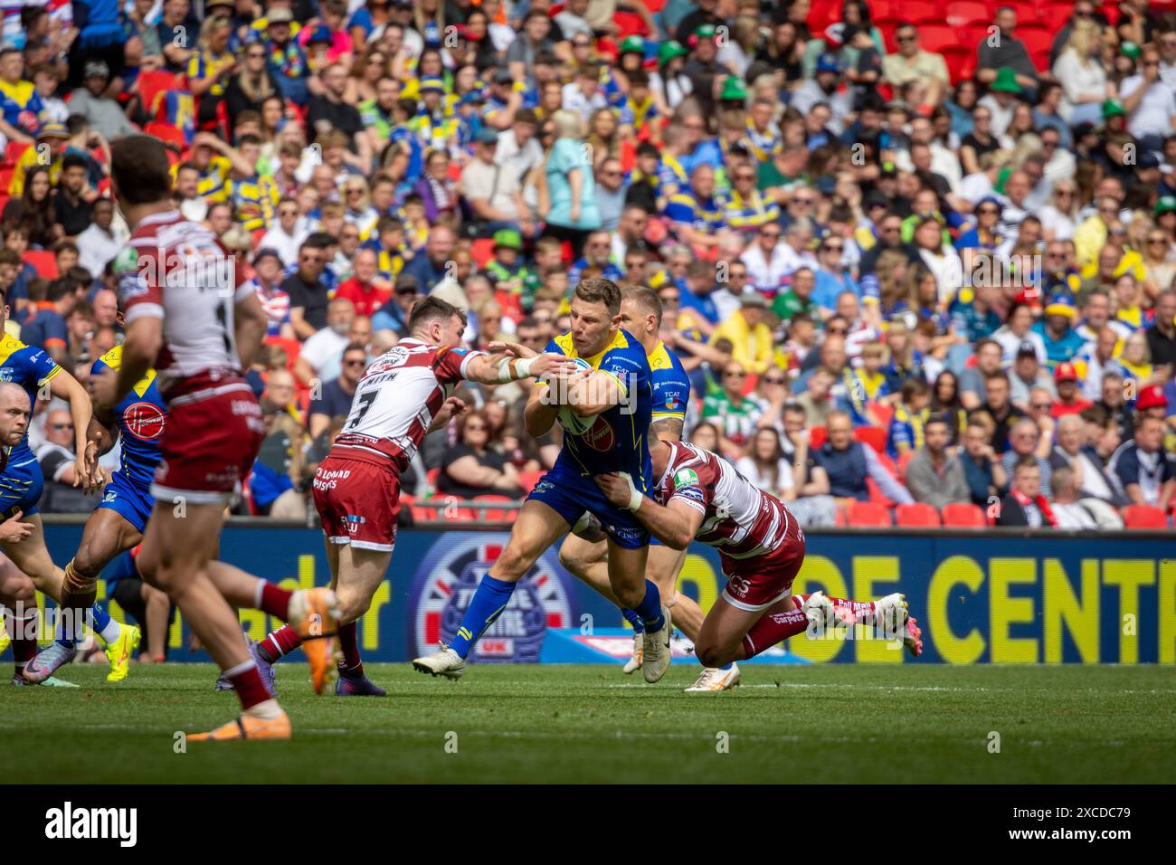 The 2024 Betfred Challenge Cup Final. George Williams is tackled by Harry Smith and Kaide Ellis ...