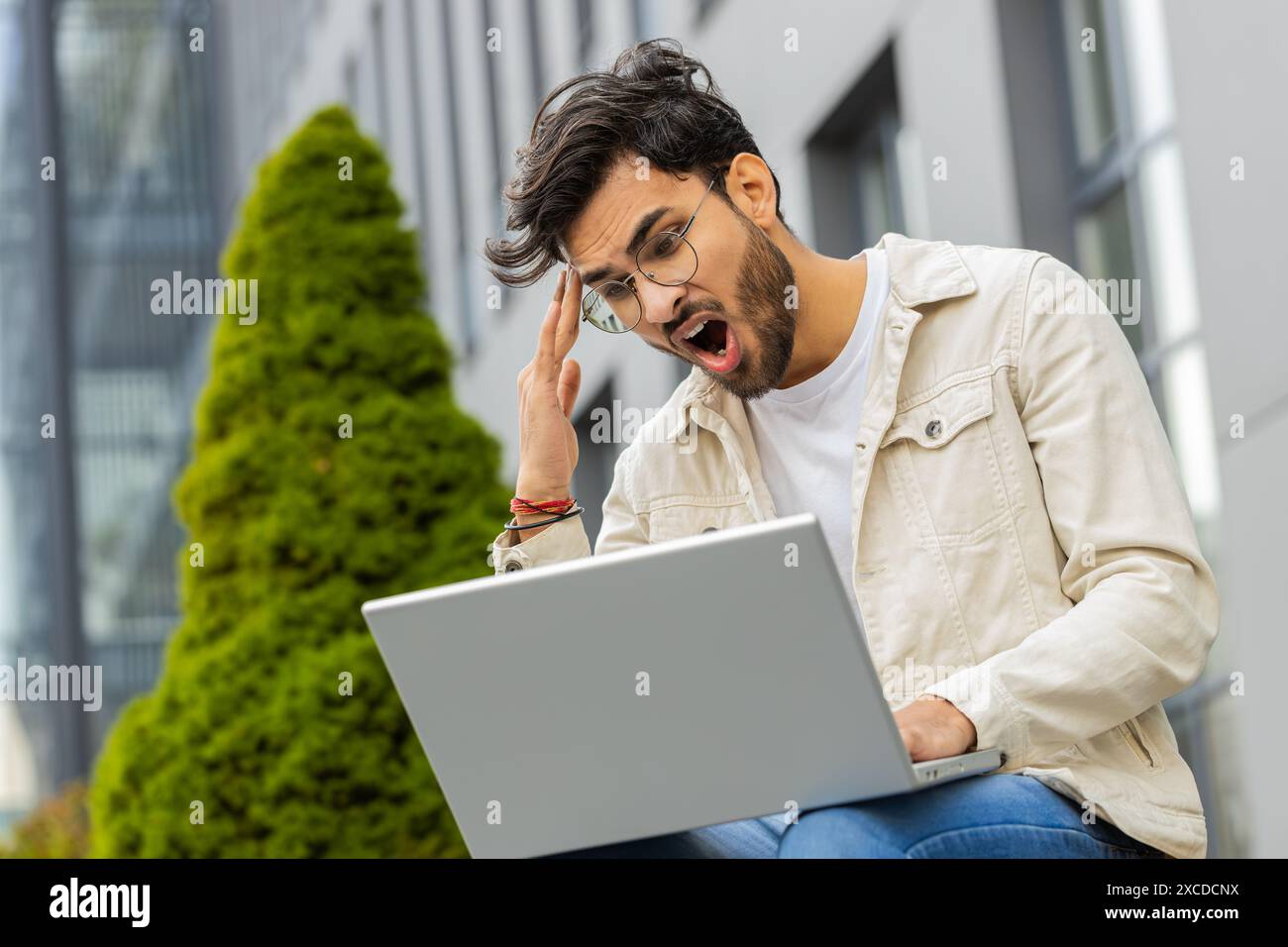 Displeased Indian man use laptop typing browsing working, loses ...