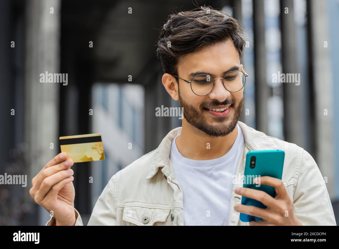 Happy Indian man using credit bank card smartphone while transferring ...