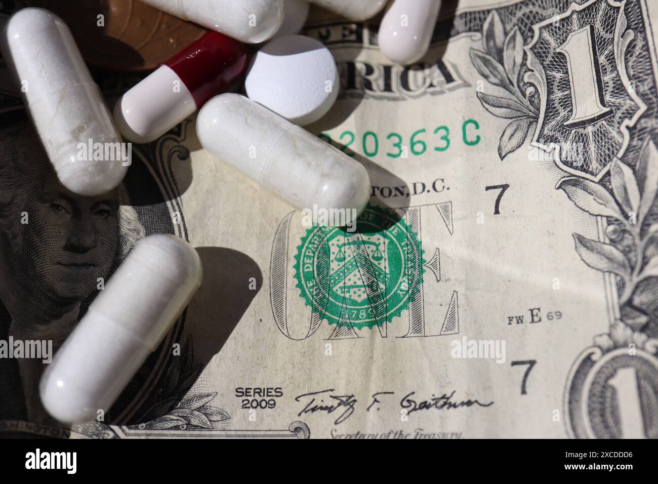White and red capsules pill spilled over a one dollar bill background ...