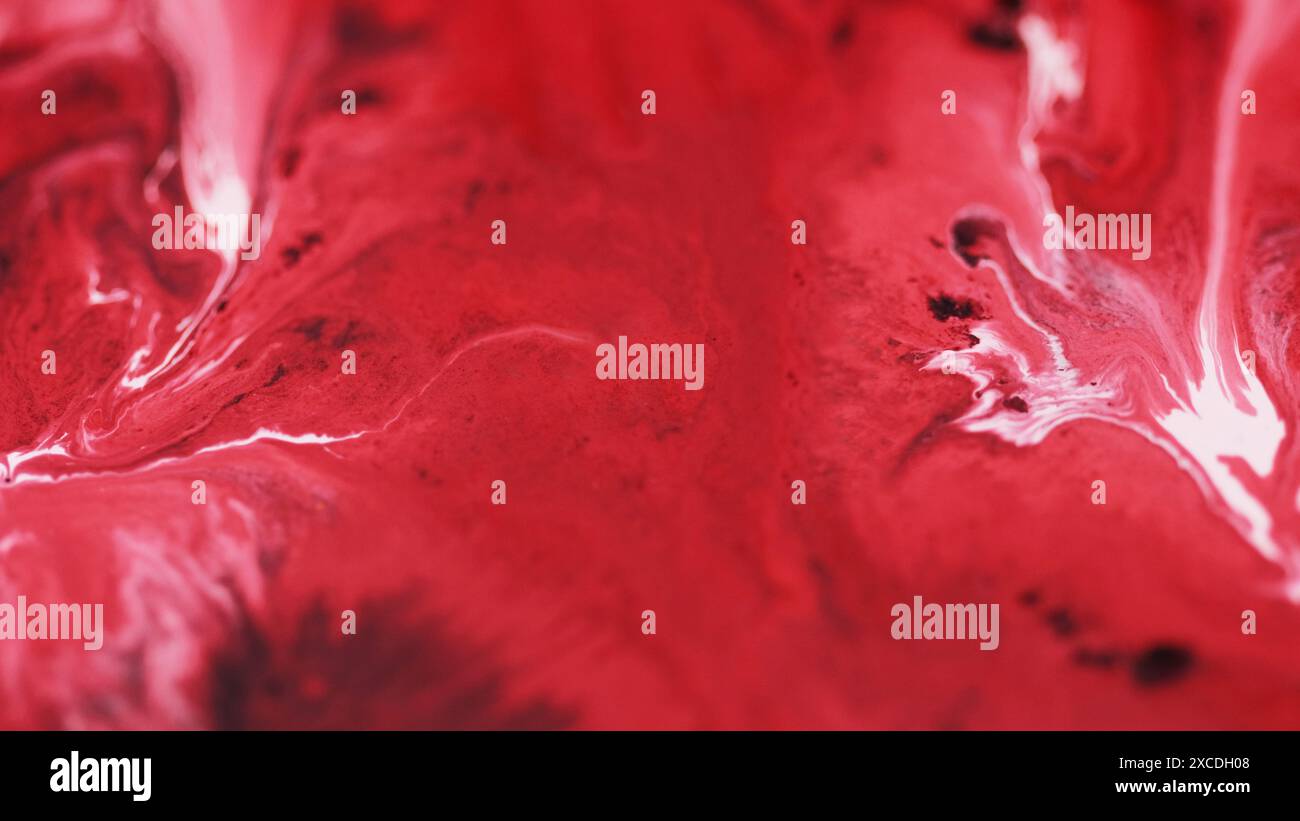 Fluid art. Color ink flow. Defocused red white black pigment dust ...