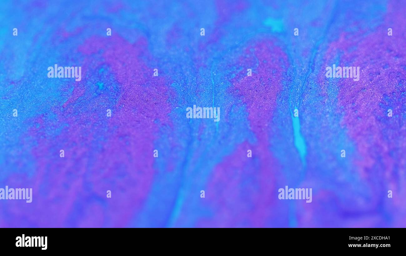 Shiny paint. Liquid glitter texture. Defocused neon blue purple color ...
