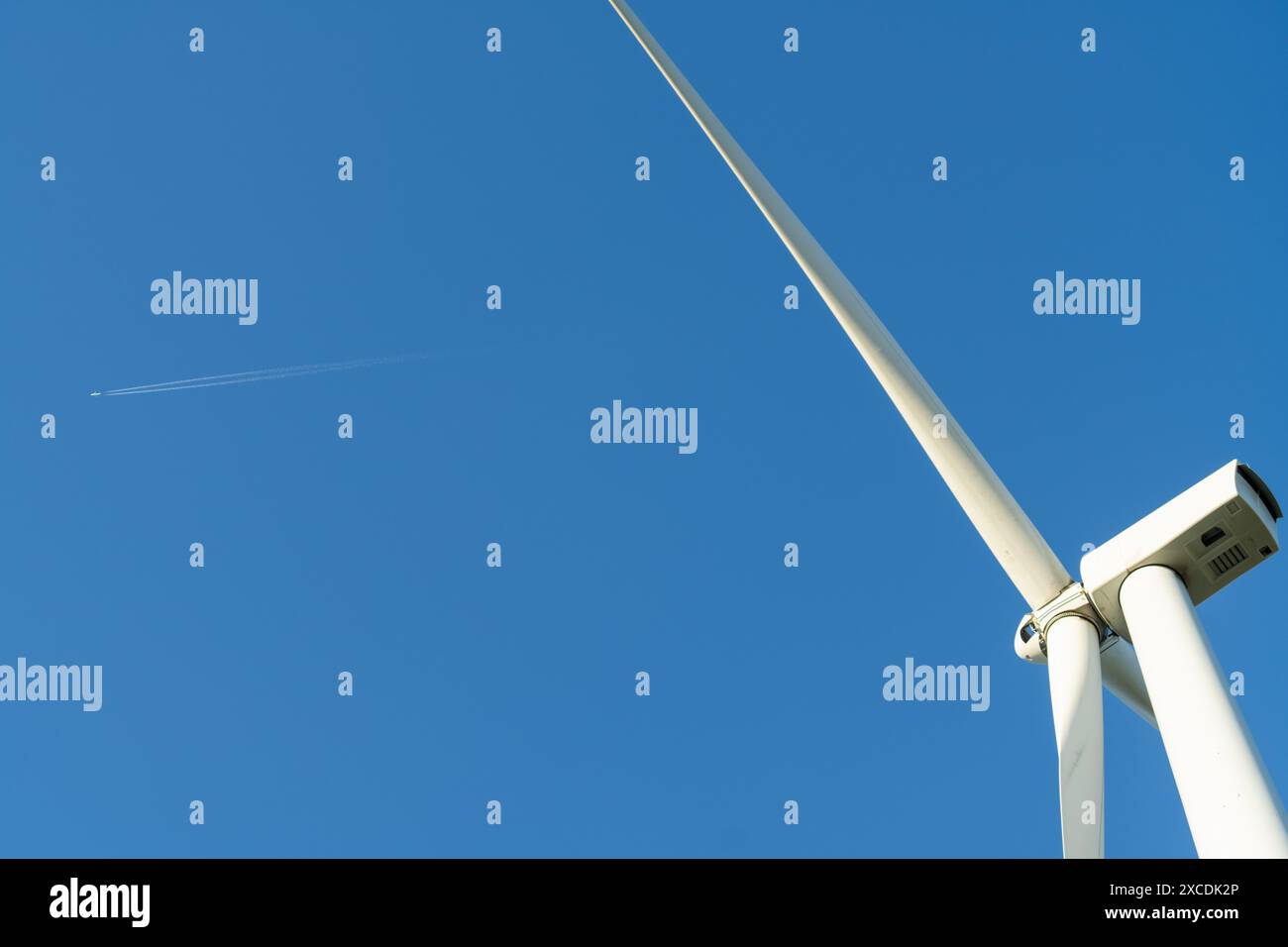 Wind turbine and plane in the blue sky Stock Photo - Alamy