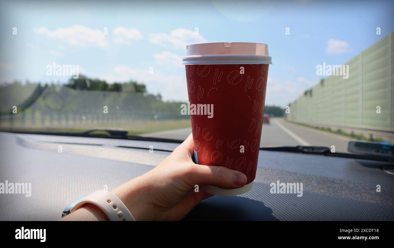 Hand holding a paper cup in the car while driving Stock Photo - Alamy