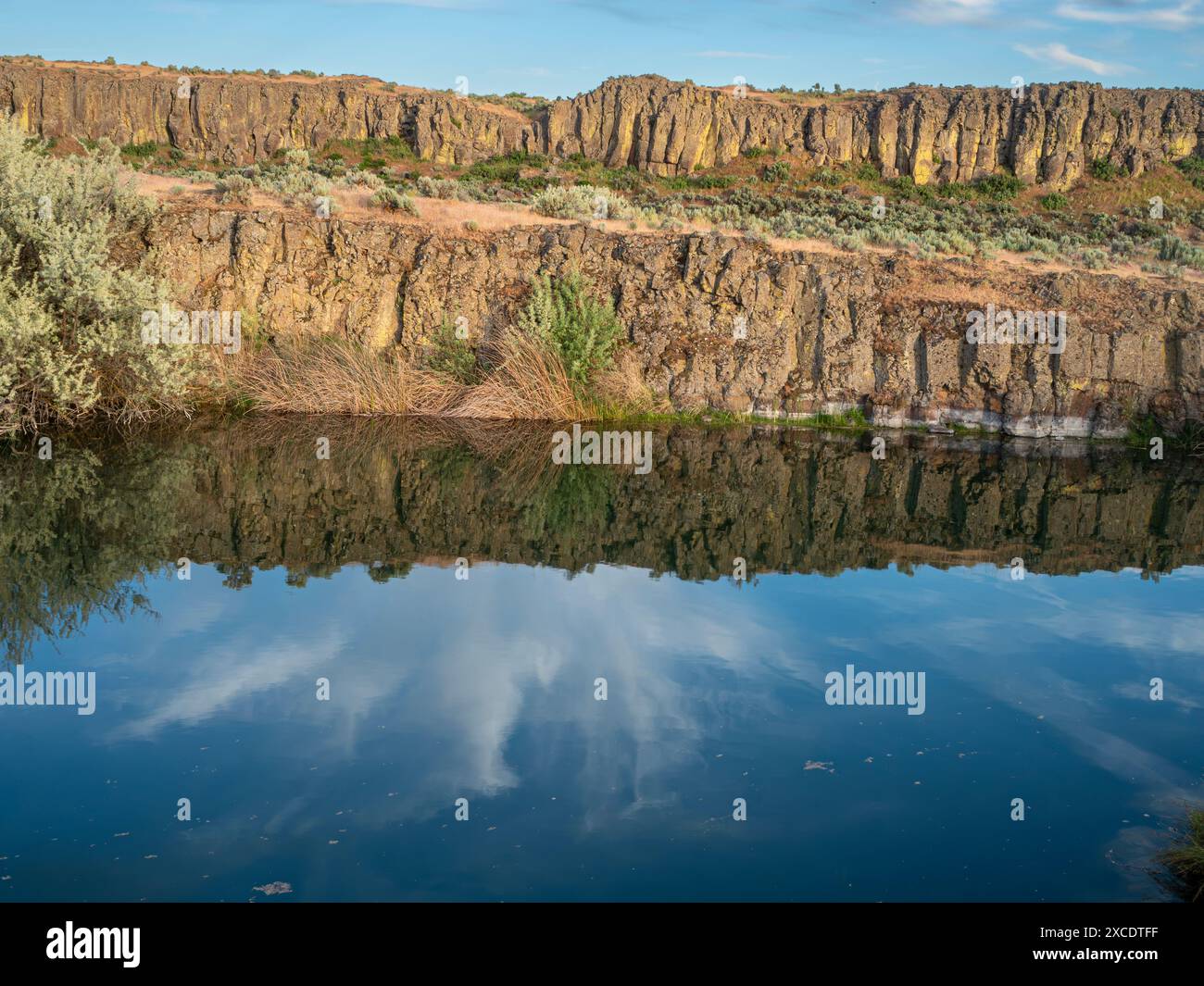 WA25421-00...WASHINGTON - Clouds reflecting in Canal Lake surrounded by ...