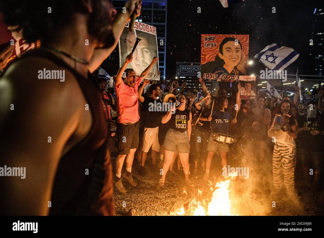 Tel Aviv, Israel. 15th June, 2024. Protestors chant around a bonfire ...