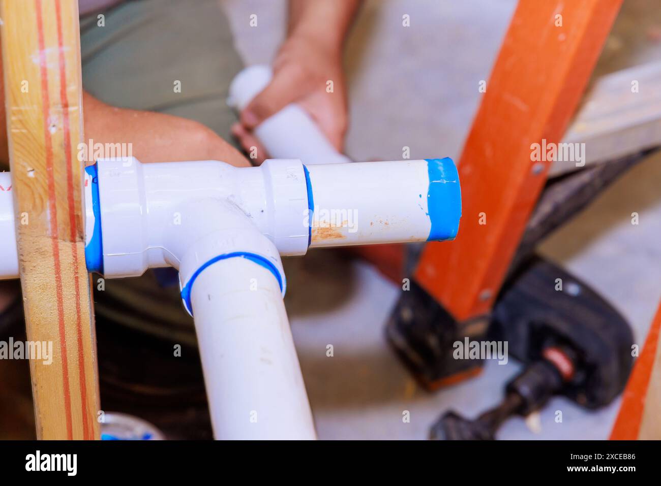 Technician plumber applies glue to join plastic PVC pipes Stock Photo ...