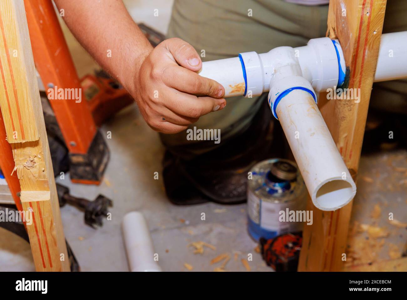 Using glue to join plastic PVC pipes, plumber uses Stock Photo - Alamy
