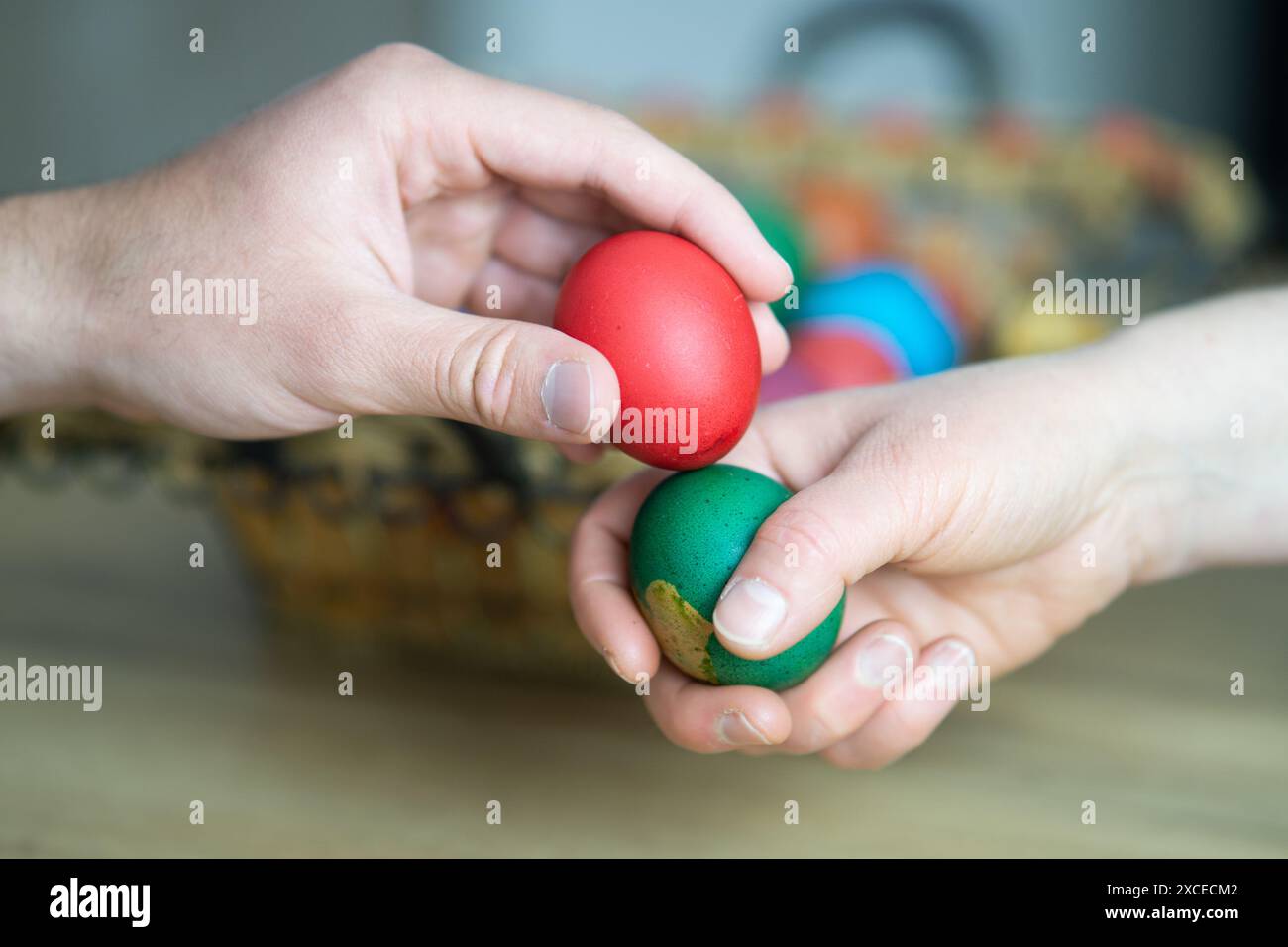 easter egg tapping, mother and son egg tapping next to basket with easter eggs, selective focus ...