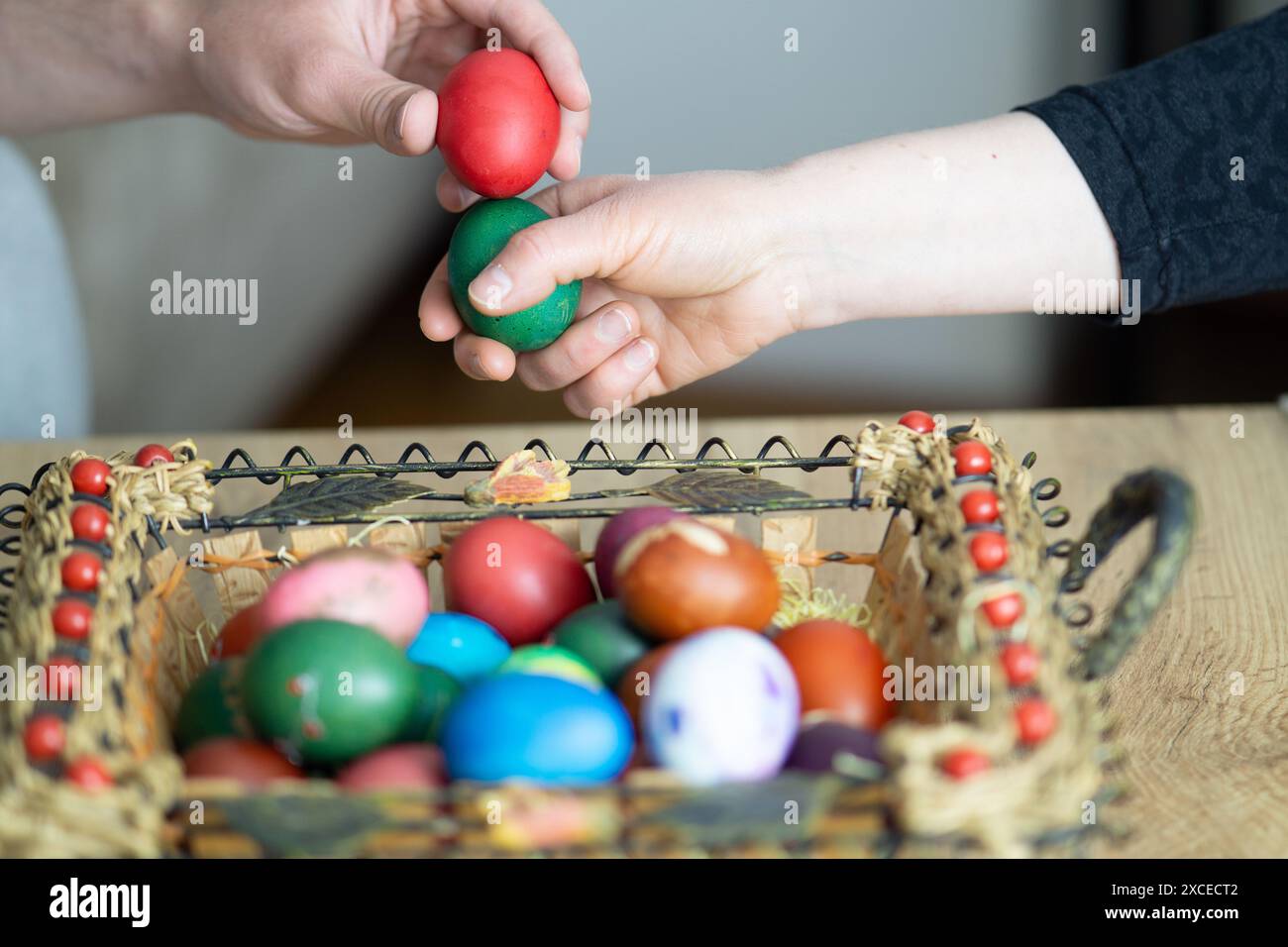 easter egg tapping, mother and son egg tapping next to basket with ...