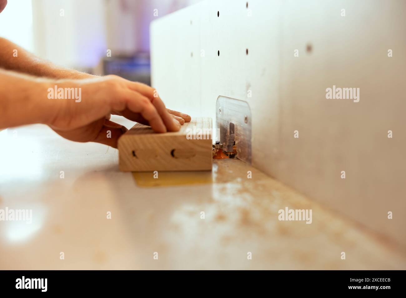 Artisan using edge jointer in assembly studio, performing specialized ...