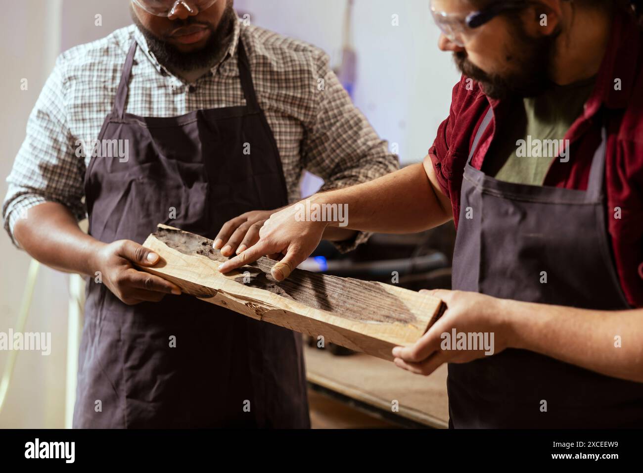 Woodworker holding timber block, showing workshop partner improvements ...