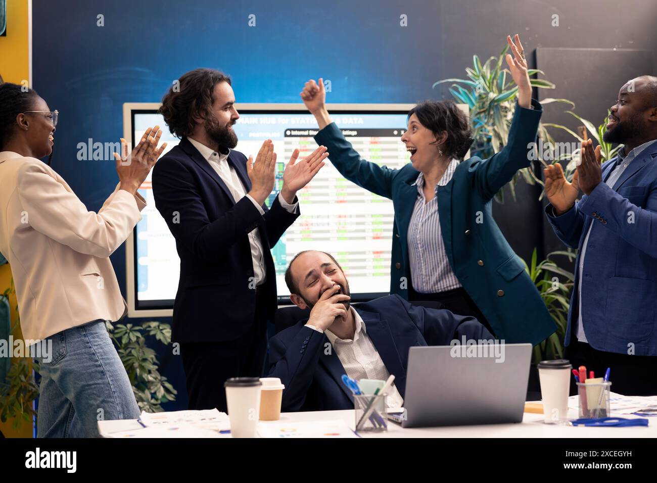 Joyful pleased colleagues celebrating project achievement after looking ...