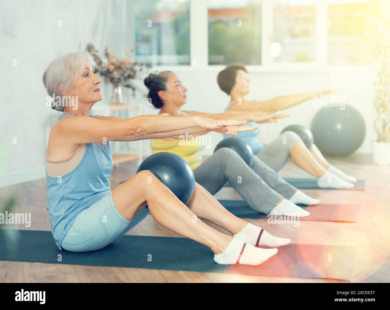 Elderly women perform softball exercises sitting on floor, workout for ...