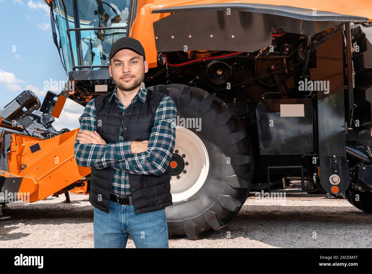 Portrait of man farm worker stands with arms crossed in front of ...