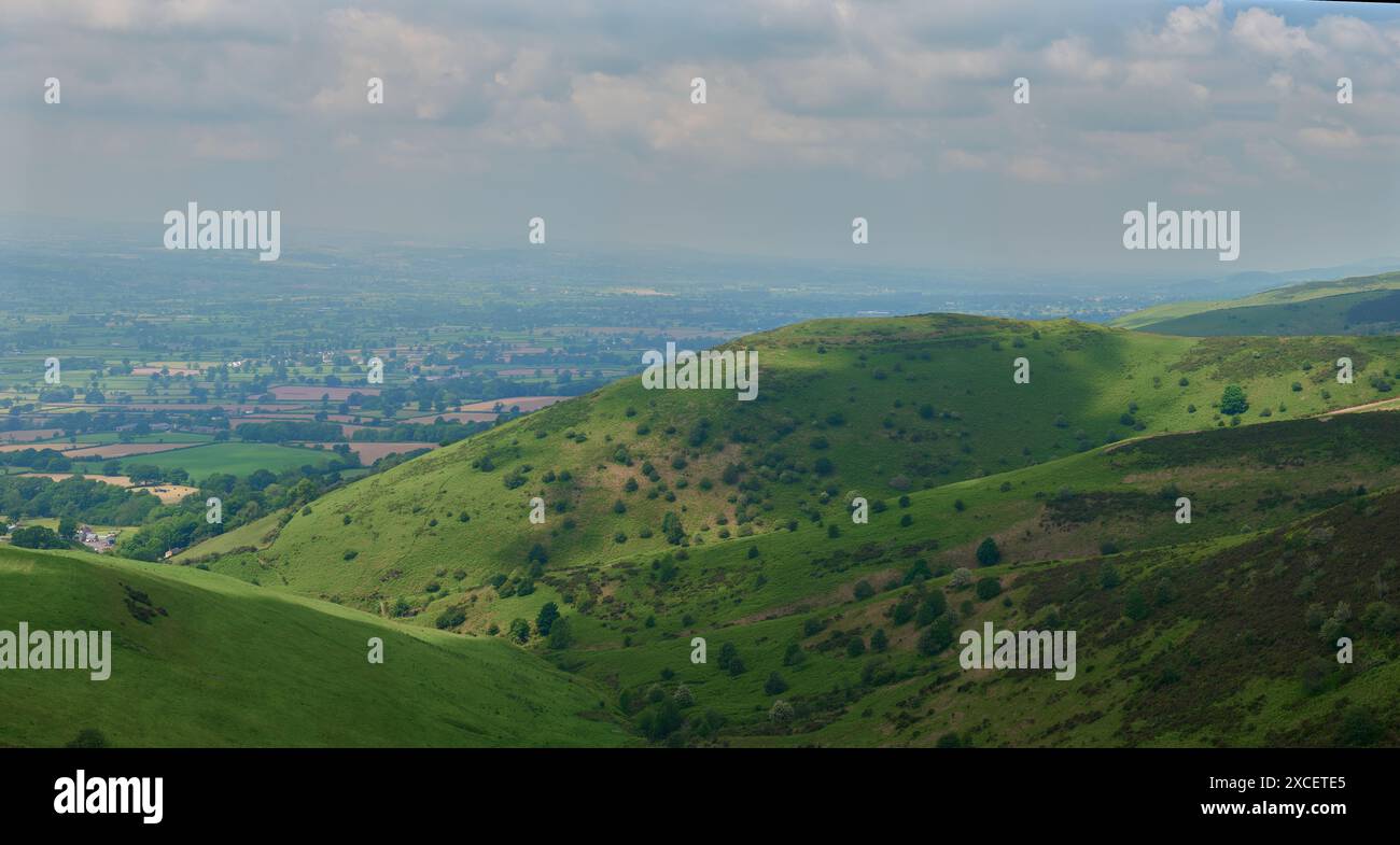 Sunshine on rolling hills making cloud shadows on hillside with hazy ...