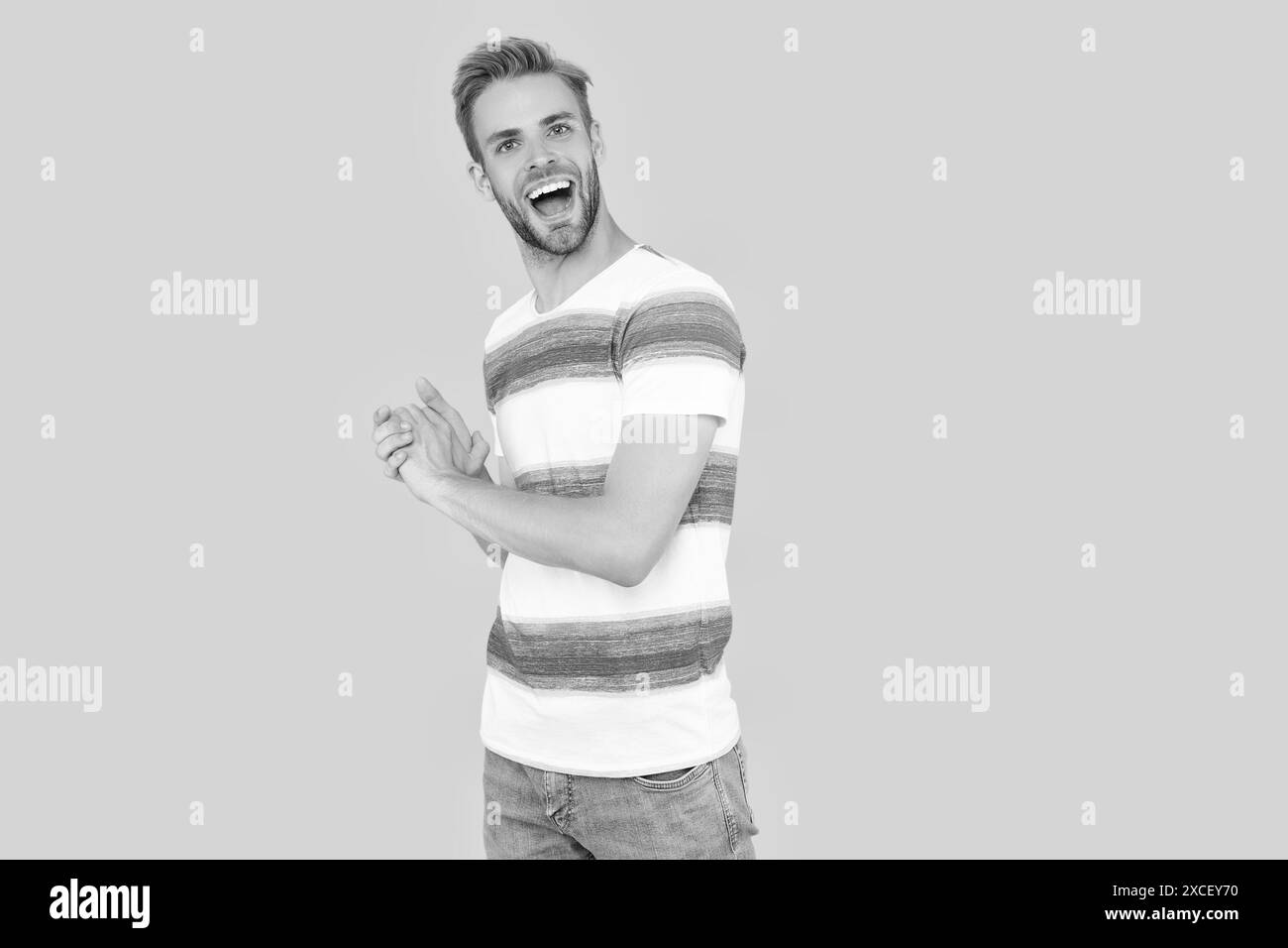 happy millennial man stands in studio. millennial man enjoys the day. A ...