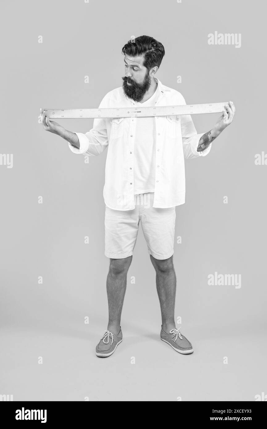 amazed man hold school ruler on background. photo of man hold school ...