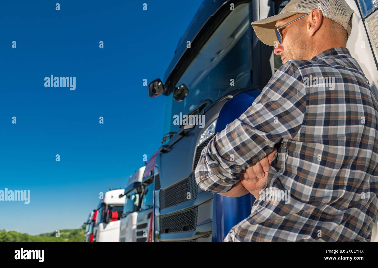 A truck driver taking a break in the sunny weather. The cab of the semi ...