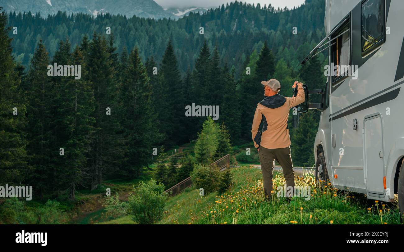 Motorhome owner stands outside a large, modern RV recreational vehicle ...