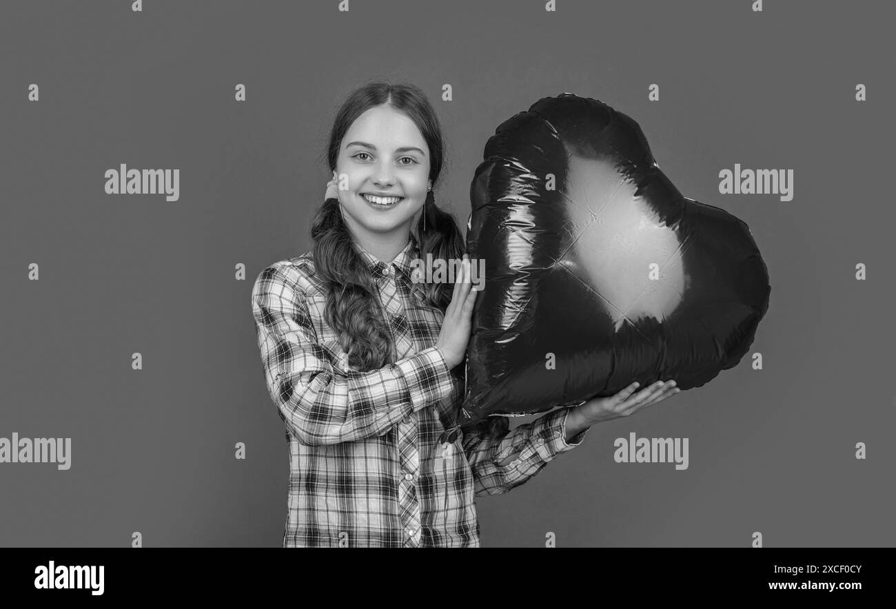 happy teen girl hold love heart balloon on red background Stock Photo ...