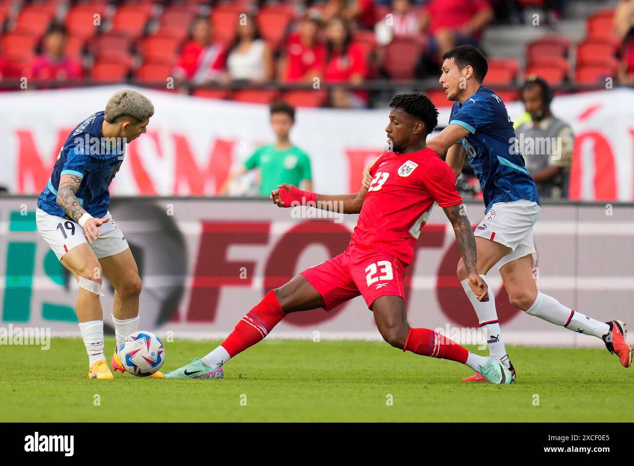 Panama's Michael Murillo, center, fights for the ball with Paraguay's ...