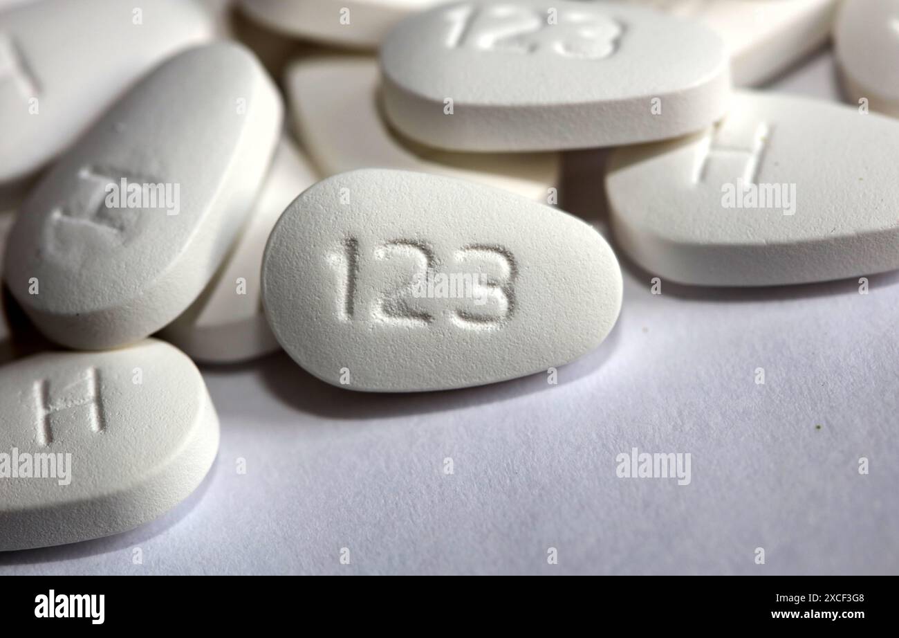 White pharmaceutical pills with numbers 123 and later h on back side ...