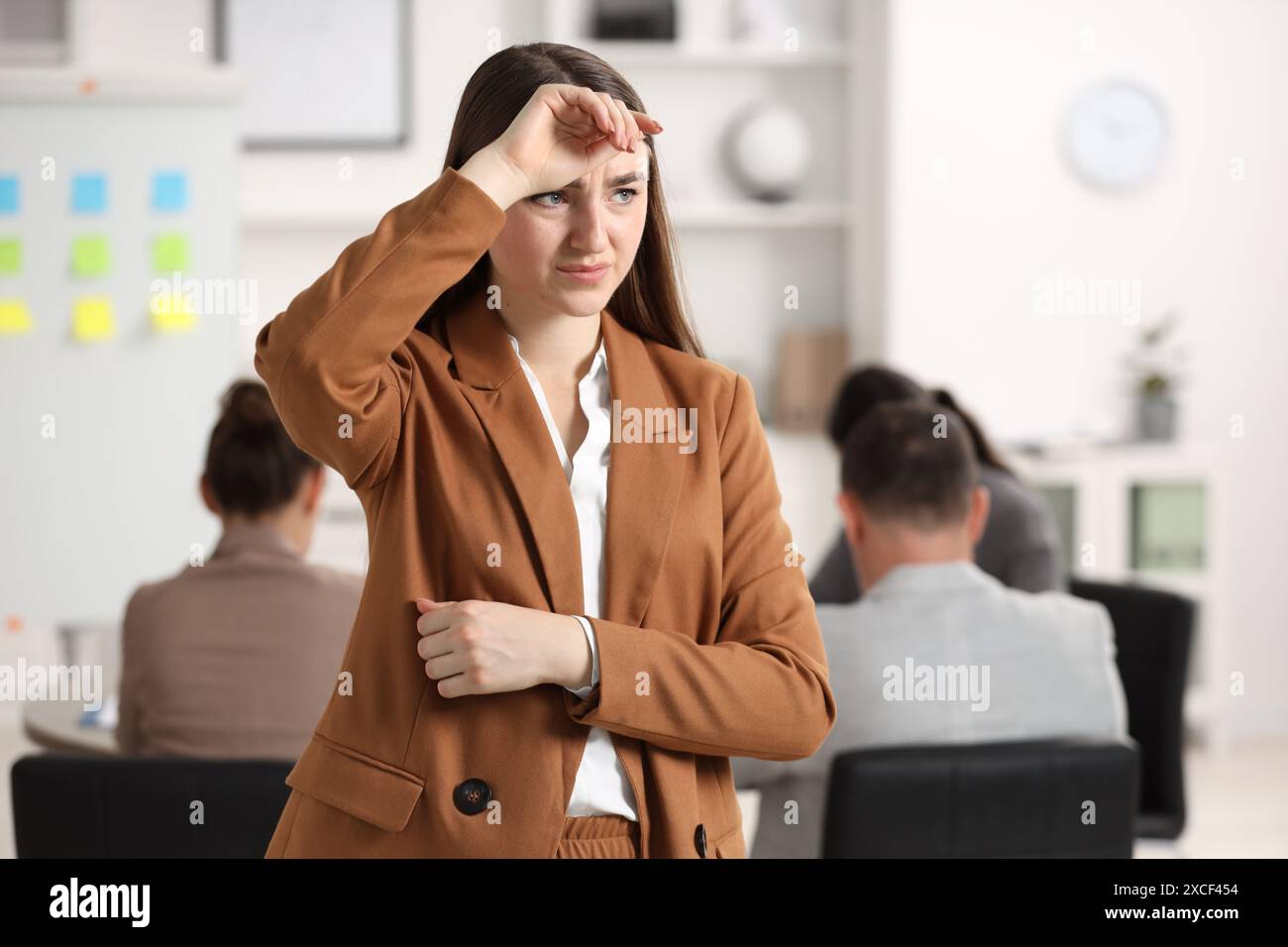 Woman feeling embarrassed during business meeting in office Stock Photo ...