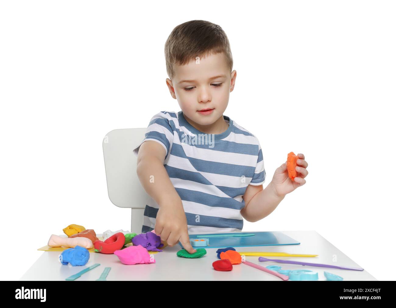 Little boy sculpting with play dough at table on white background Stock ...