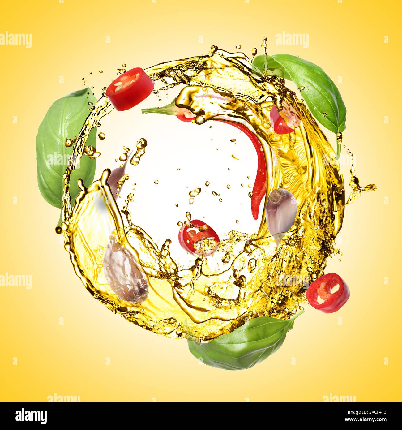 Cooking oil splash with chili pepper, garlic and basil in air on golden ...