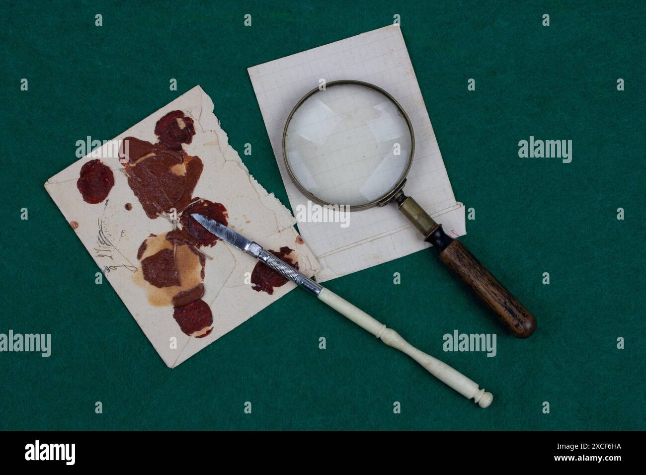Retro envelope opener knife with magnifying glass and vintage letter envelope on table Stock ...