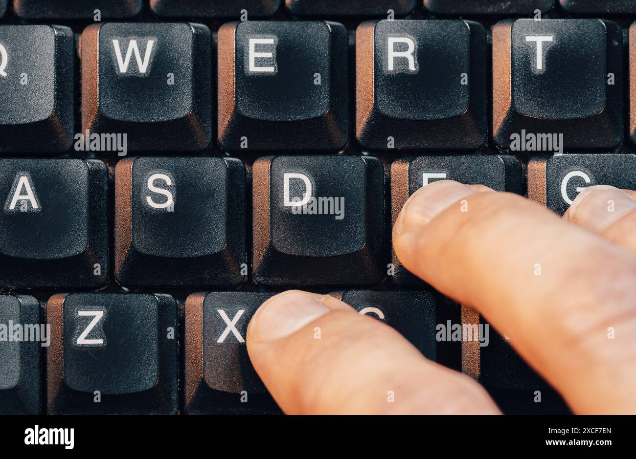 Mans hand resting on an old retro style aesthetic laptop computer ...