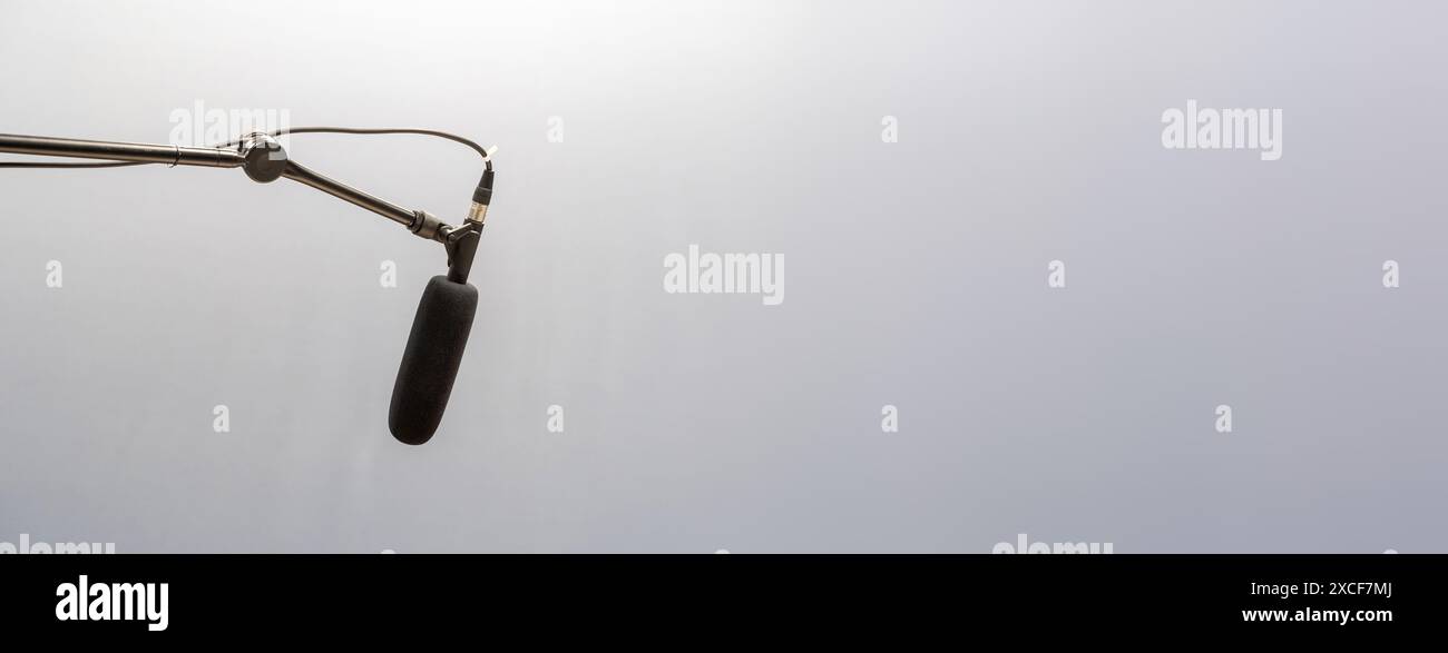 Simple black studio mic, microphone hanging placed on a long high top ...