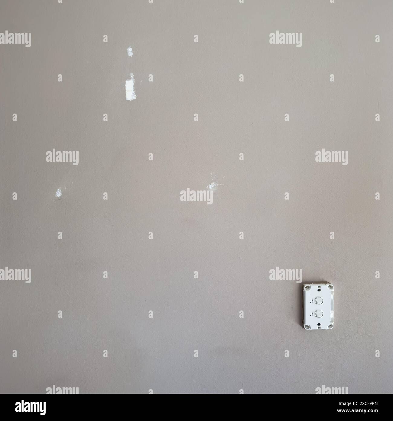 Blank wall with light switch patched with filler ready for painting ...