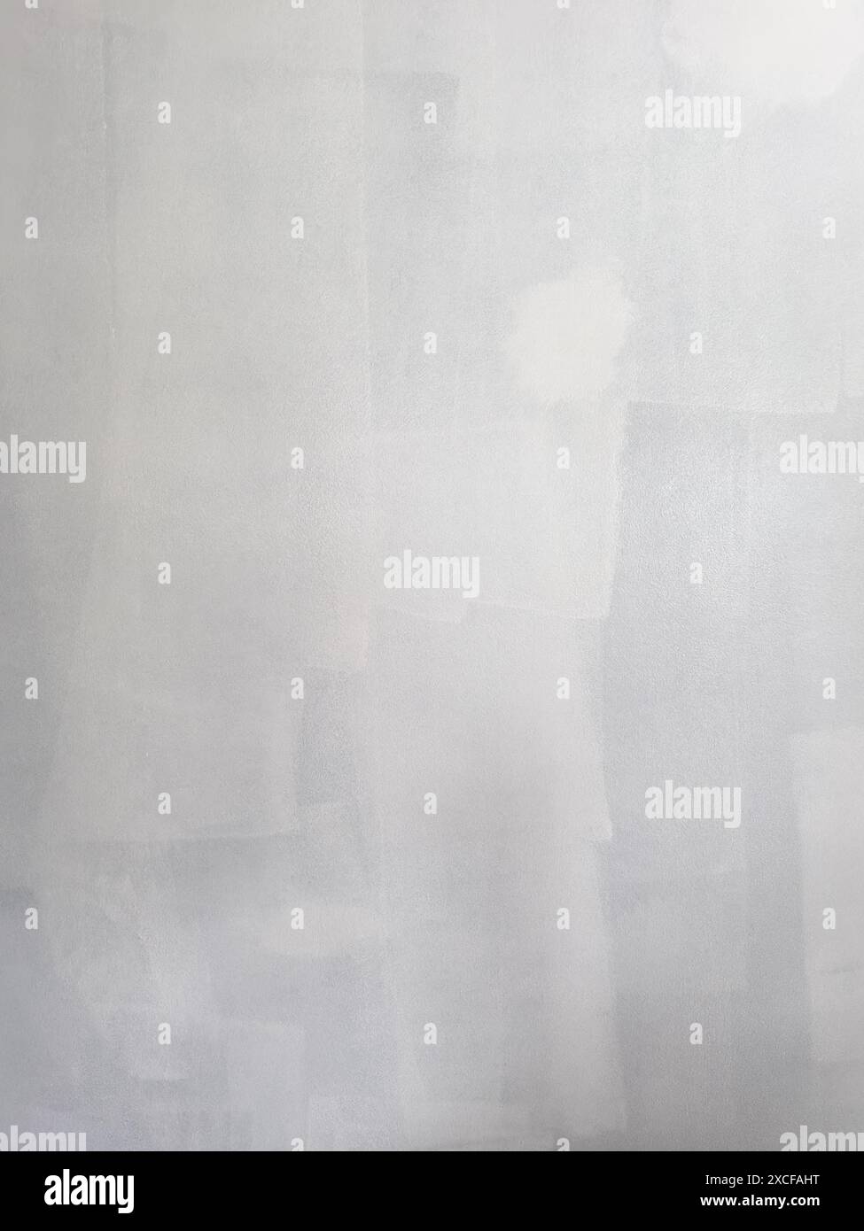 Completely blank freshly roller painted white wall with patchy marks in ...