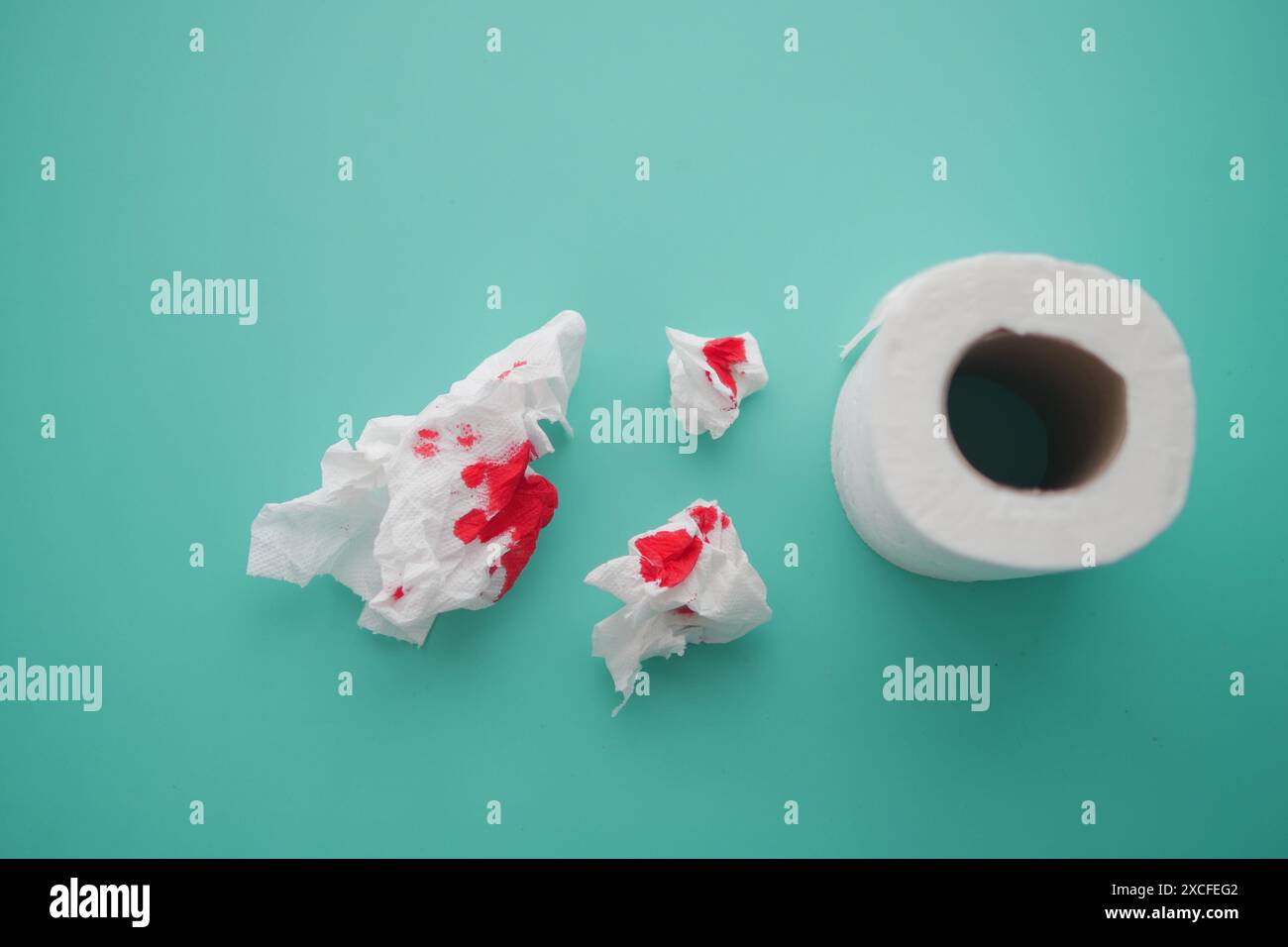 Blood on the tissues on light green background Stock Photo - Alamy