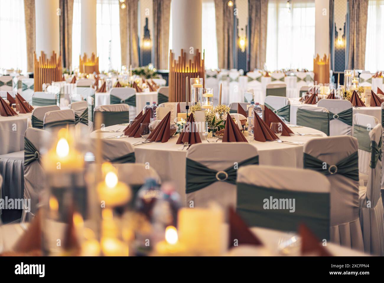 Decorated tables and modern lighting in a banquet hall for wedding ...