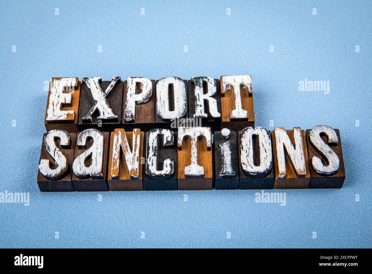EXPORT SANCTIONS. Wooden alphabet letter blocks on blue textured ...