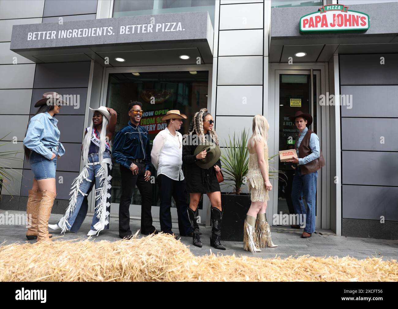 EDITORIAL USE ONLY Members of the public queue up outside Papa Johns in ...