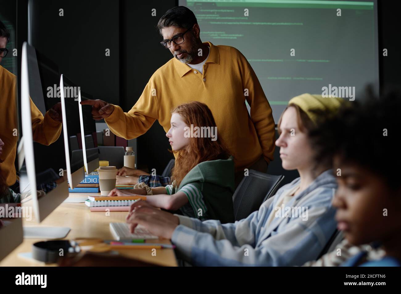 Mature biracial Computer Science teacher helping Caucasian girl to find ...