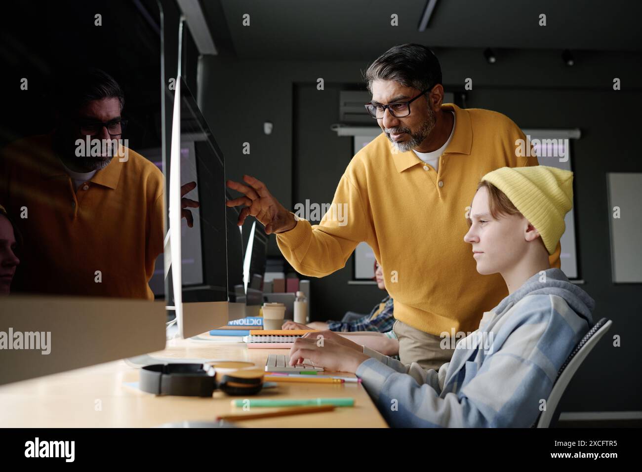 Mature biracial teacher of Computer Science explaining subject to one ...