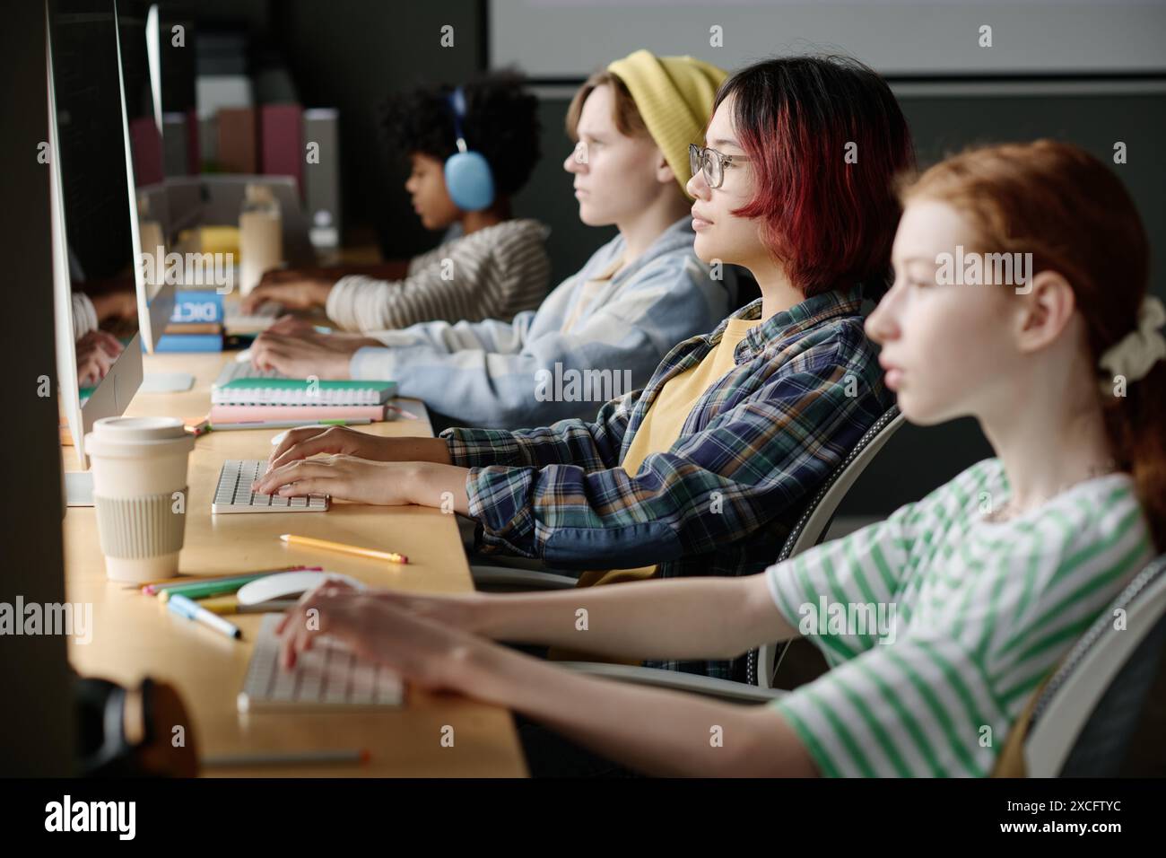 Selective focus shot of Asian teen girl and her multi-ethnic classmates ...