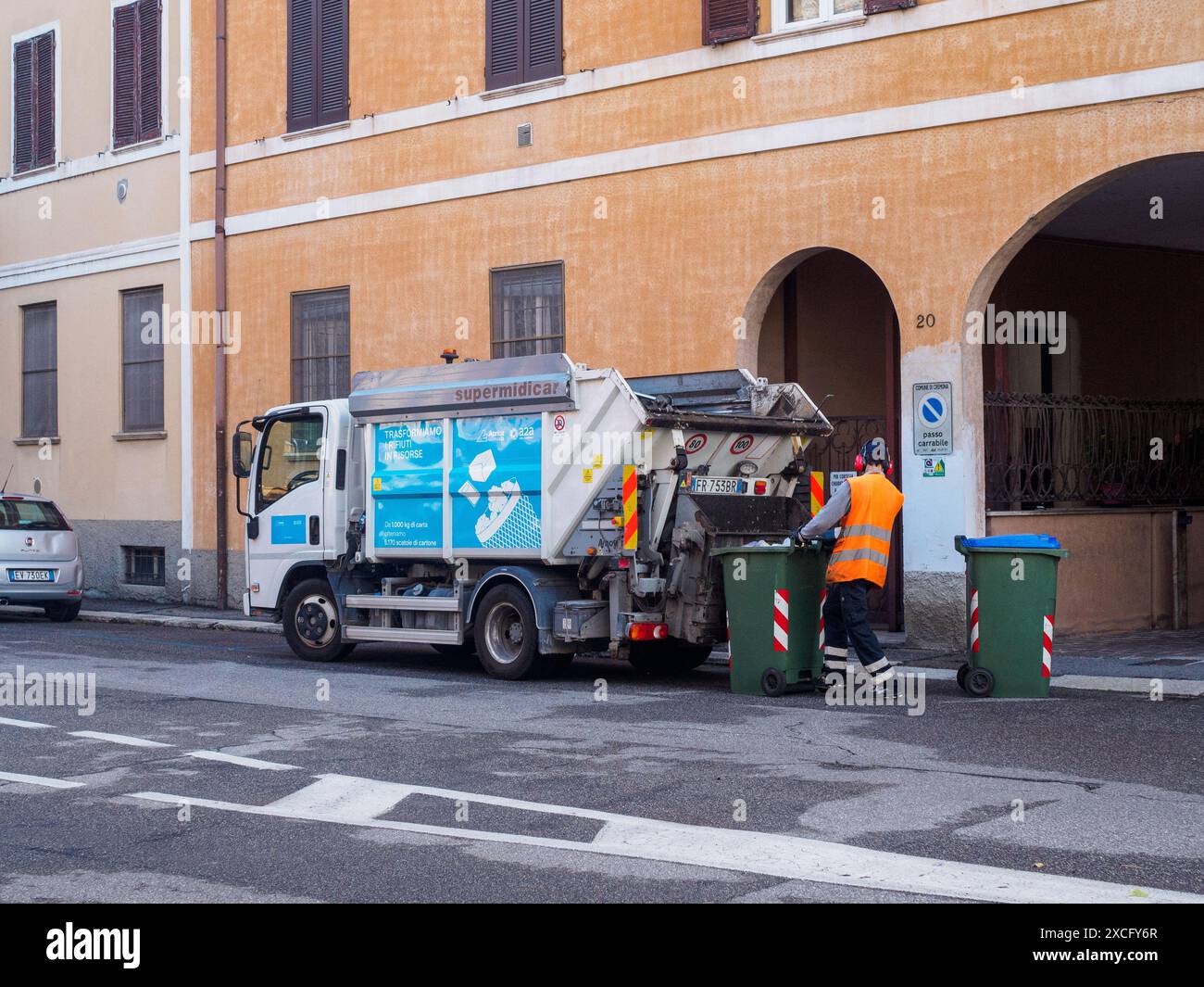 Cremona, Italy - June 10th 2024 Garbage man wearing orange vest ...