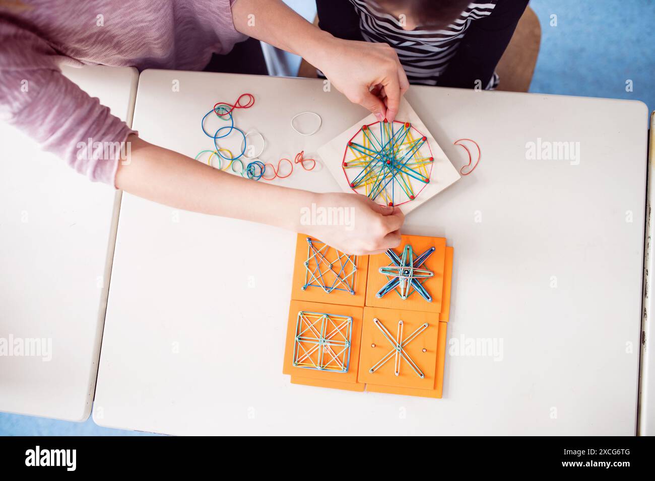 Top view of teacher using geoboard in class, teaching students ...