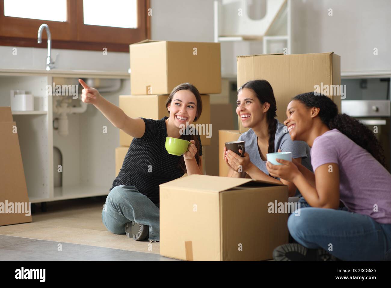 Three happy roommates planning decoration pointing away moving house ...